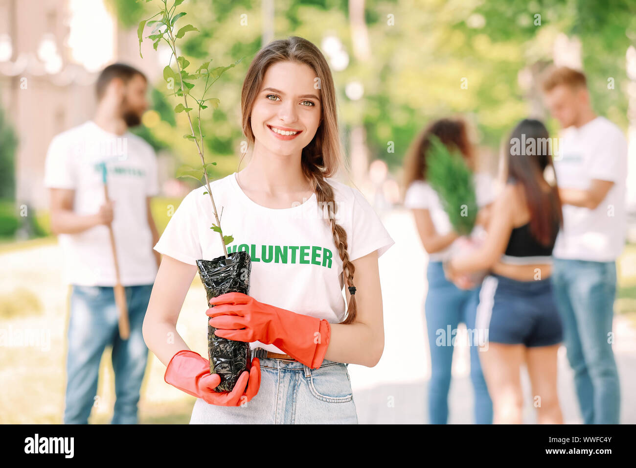 Female volunteer with young tree outdoors Stock Photo - Alamy