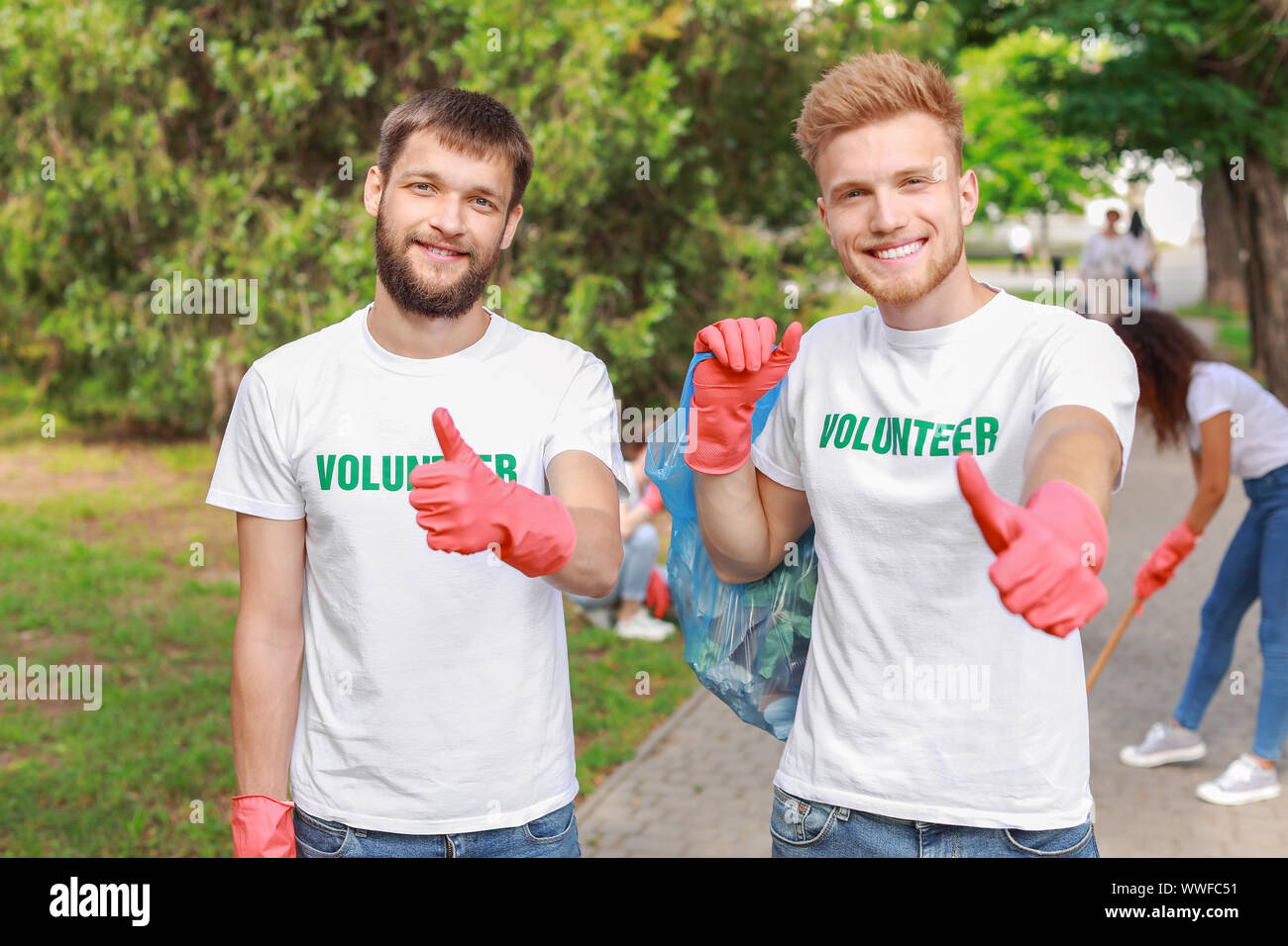 Volunteers gathering garbage in park Stock Photo - Alamy