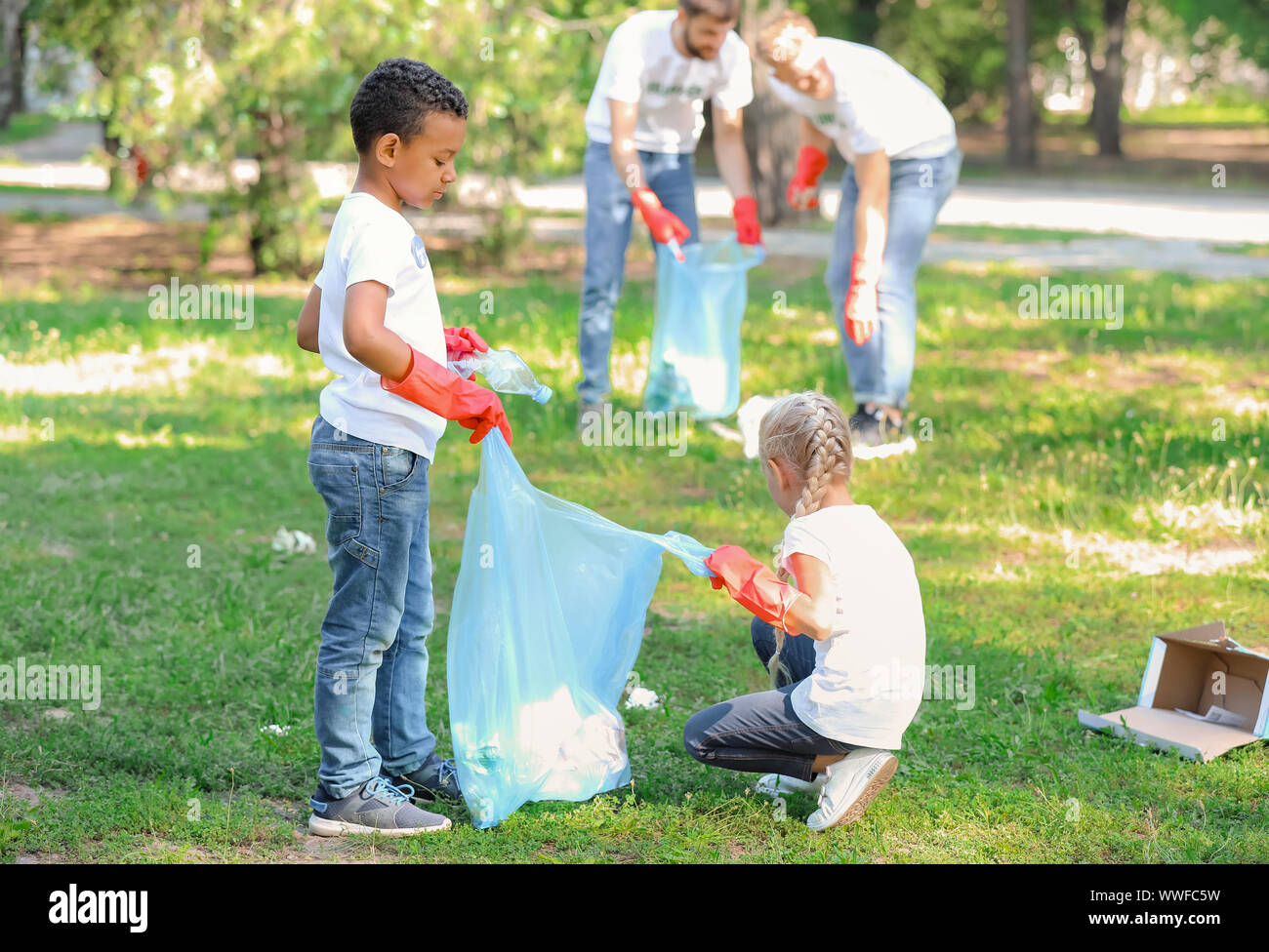 Little volunteers gathering garbage in park Stock Photo - Alamy
