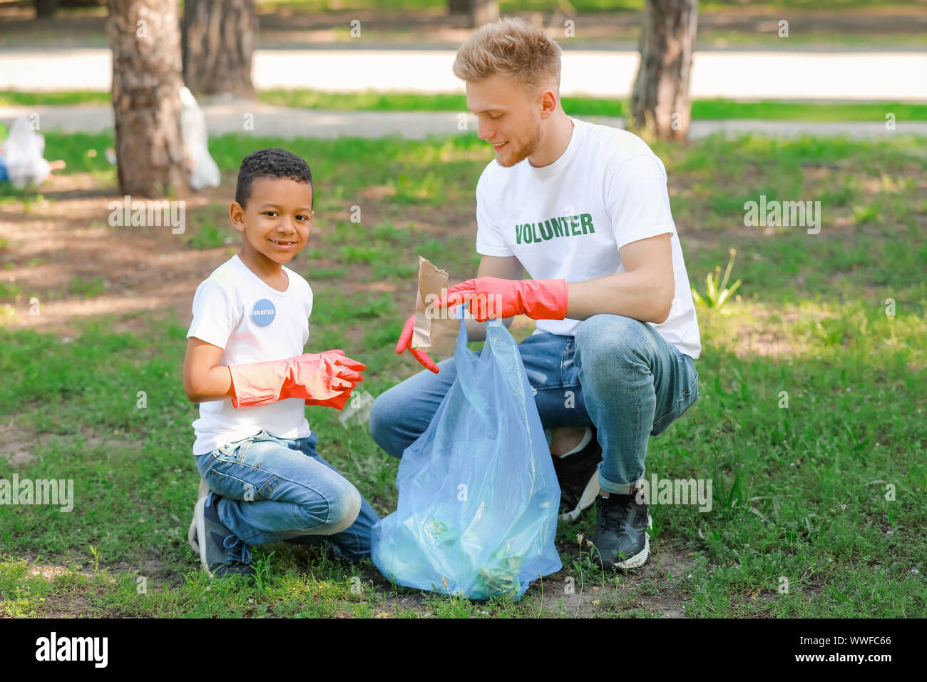 Volunteers gathering garbage in park Stock Photo - Alamy