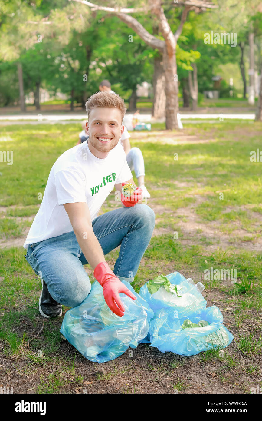 Male volunteer gathering garbage in park Stock Photo - Alamy