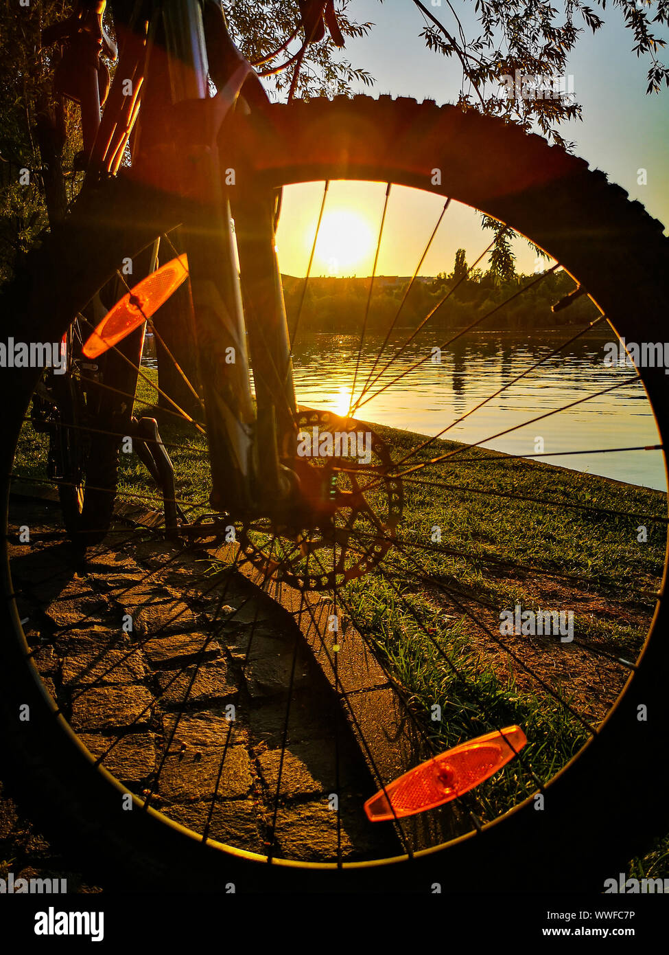 Sunset seen by bicycle wheel Stock Photo - Alamy