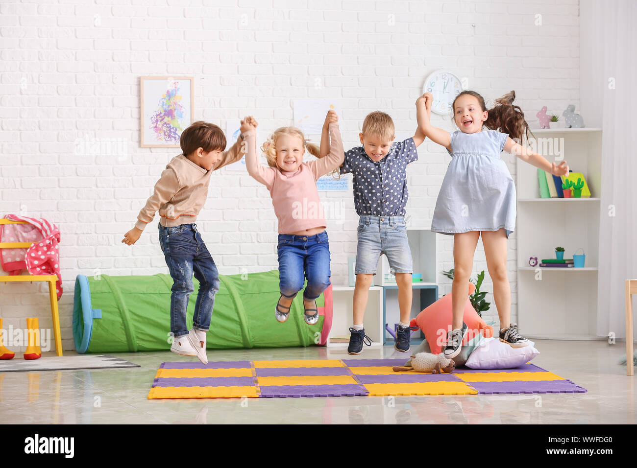 Jumping little children in kindergarten Stock Photo - Alamy