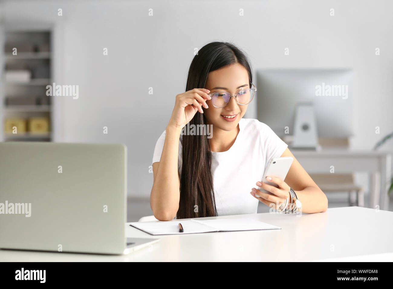 Young Asian student using mobile phone while preparing for exam Stock ...