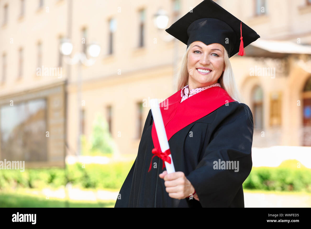 Mature woman in bachelor robe outdoors Stock Photo - Alamy