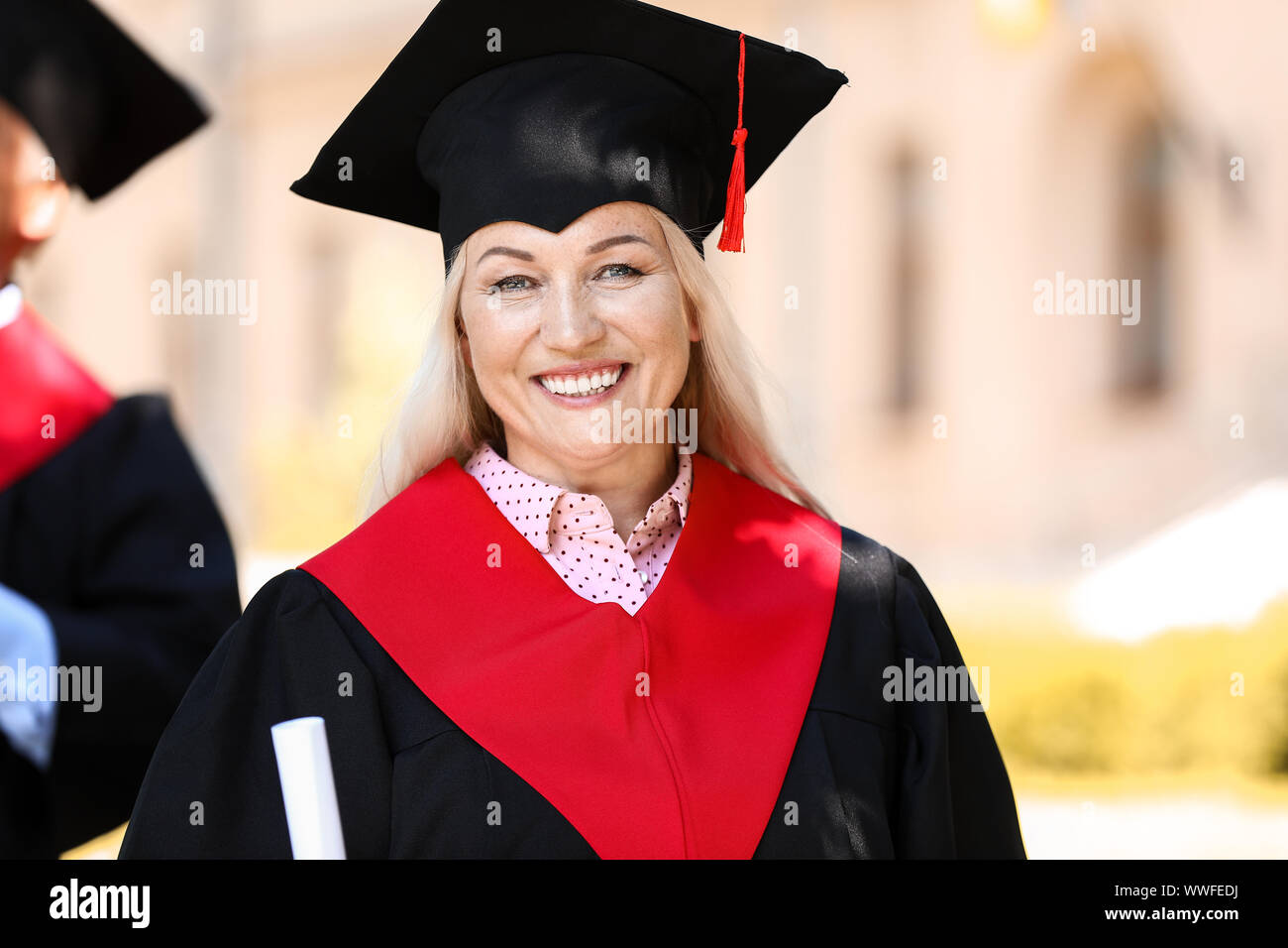 Mature woman in bachelor robe outdoors Stock Photo - Alamy