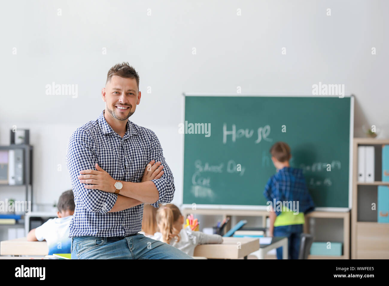 Portrait of male teacher in classroom Stock Photo - Alamy