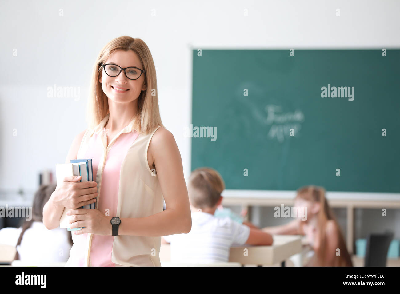 Portrait of female teacher in classroom Stock Photo - Alamy