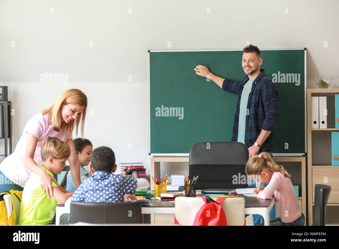 Teachers conducting lesson in classroom Stock Photo - Alamy