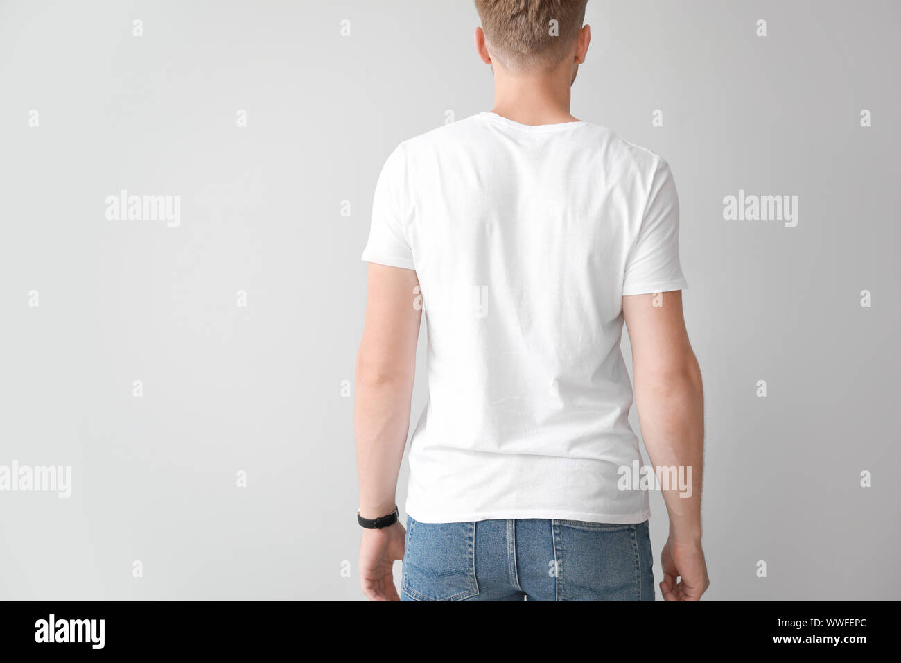 Man in stylish t-shirt on light background, back view Stock Photo - Alamy