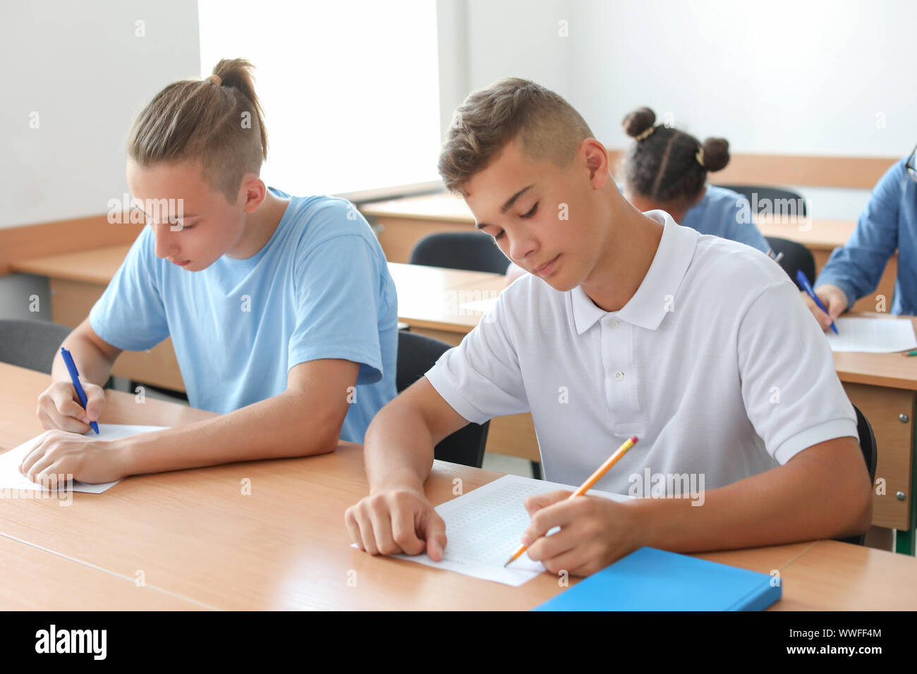 Teenage boys passing school test in classroom Stock Photo - Alamy