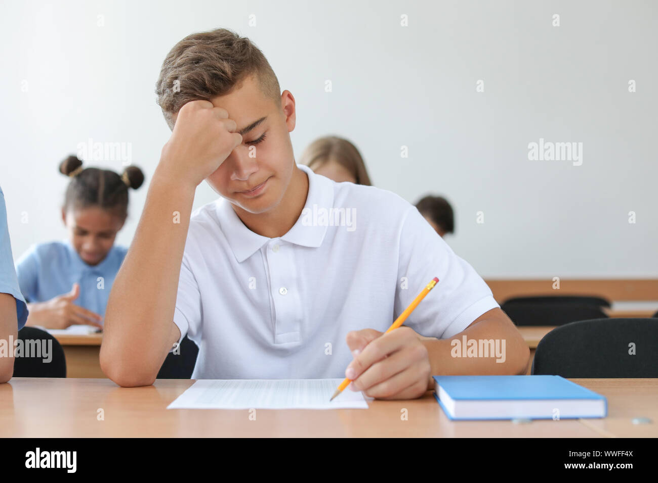 Teenage boy passing school test in classroom Stock Photo - Alamy