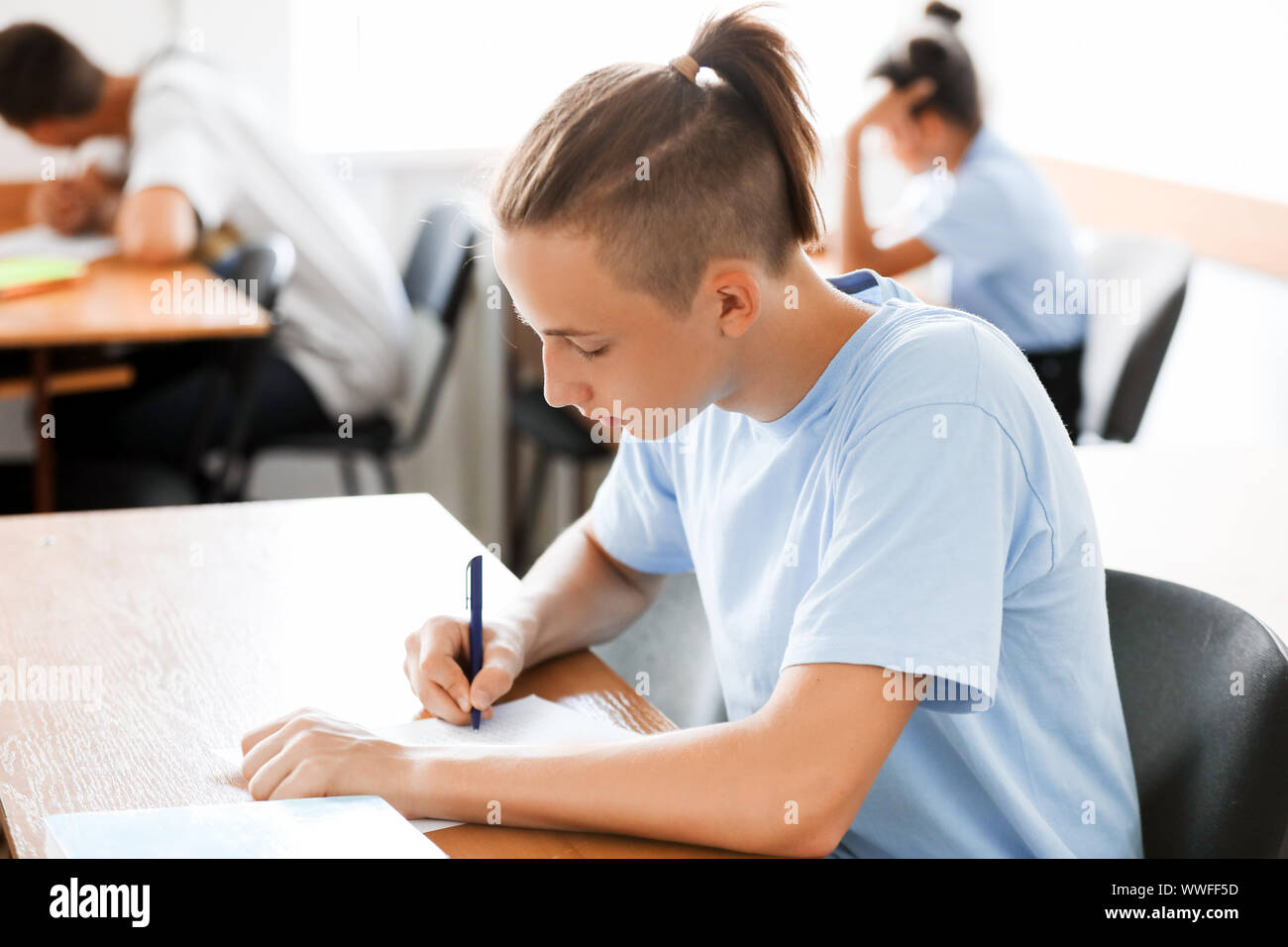 Teenage boy passing school test in classroom Stock Photo - Alamy