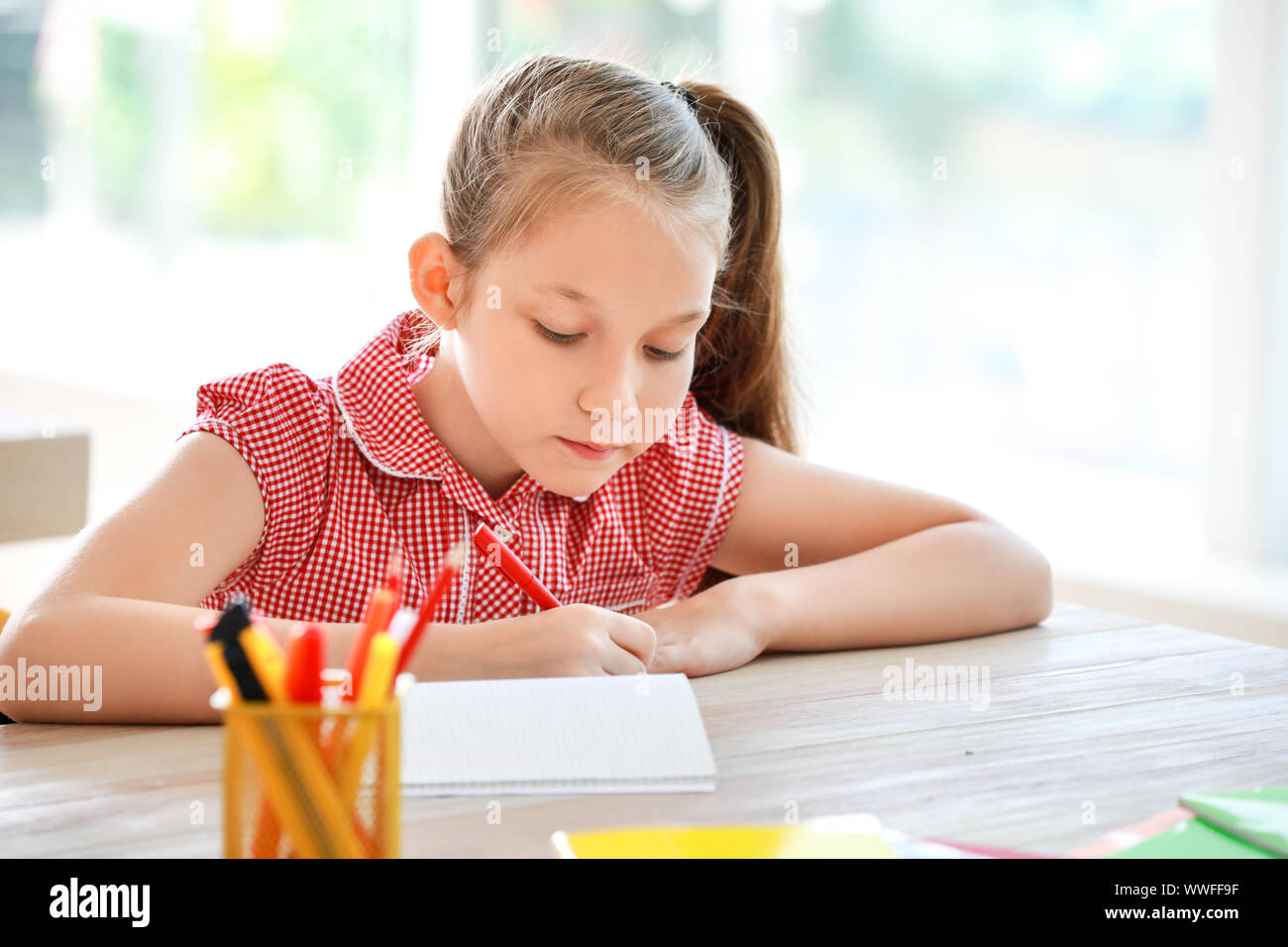 Cute little girl during lesson in classroom Stock Photo - Alamy