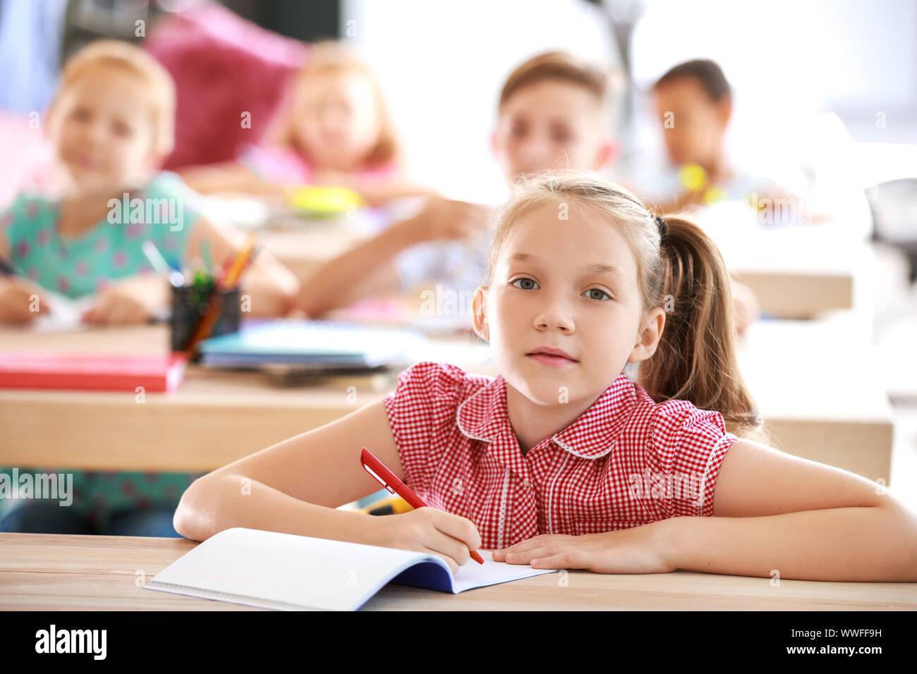 Cute little girl during lesson in classroom Stock Photo - Alamy