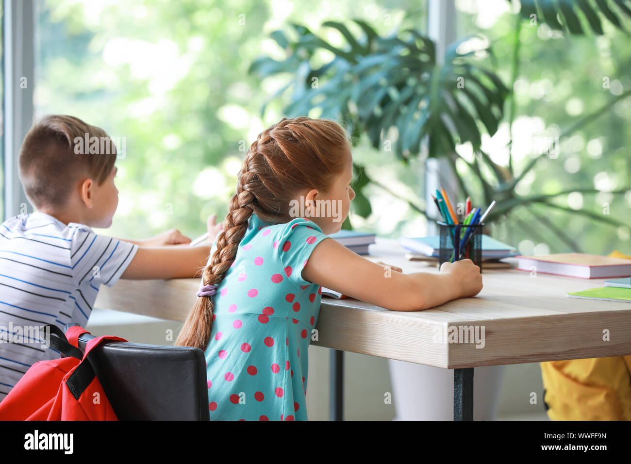 Cute little pupils during lesson in classroom Stock Photo - Alamy