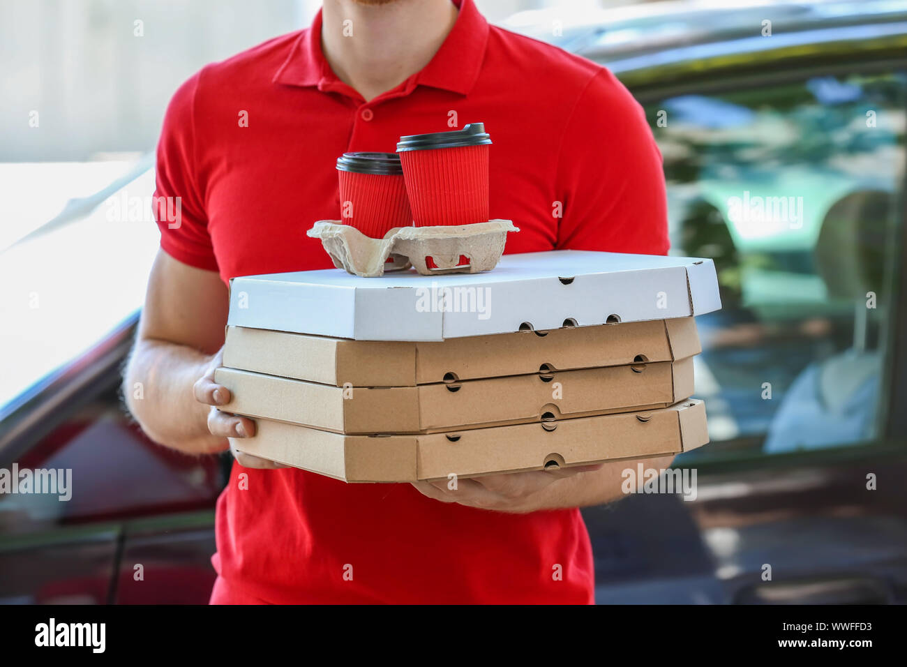 Worker of food delivery service near car outdoors Stock Photo - Alamy