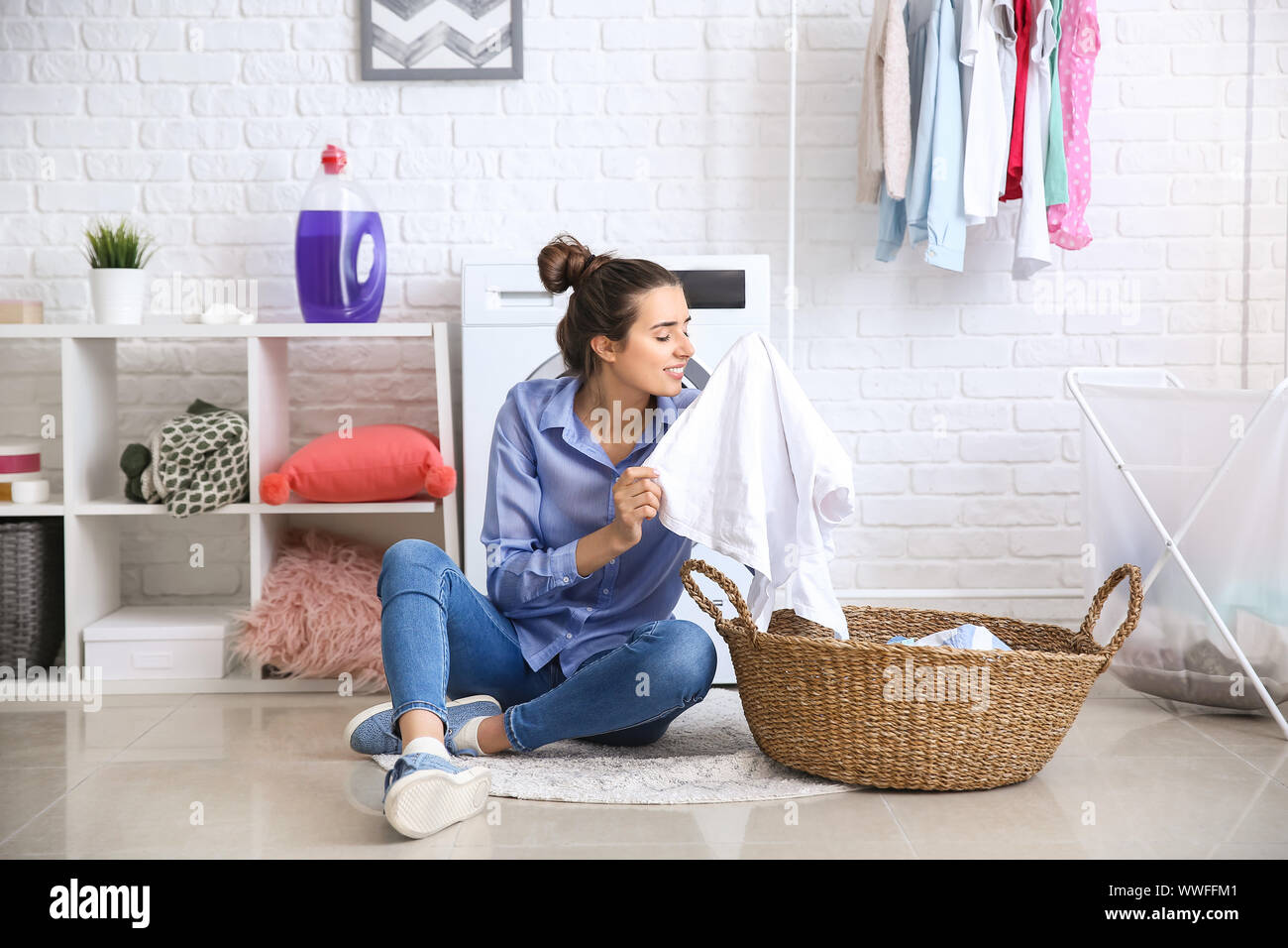 Beautiful young woman doing laundry at home Stock Photo - Alamy