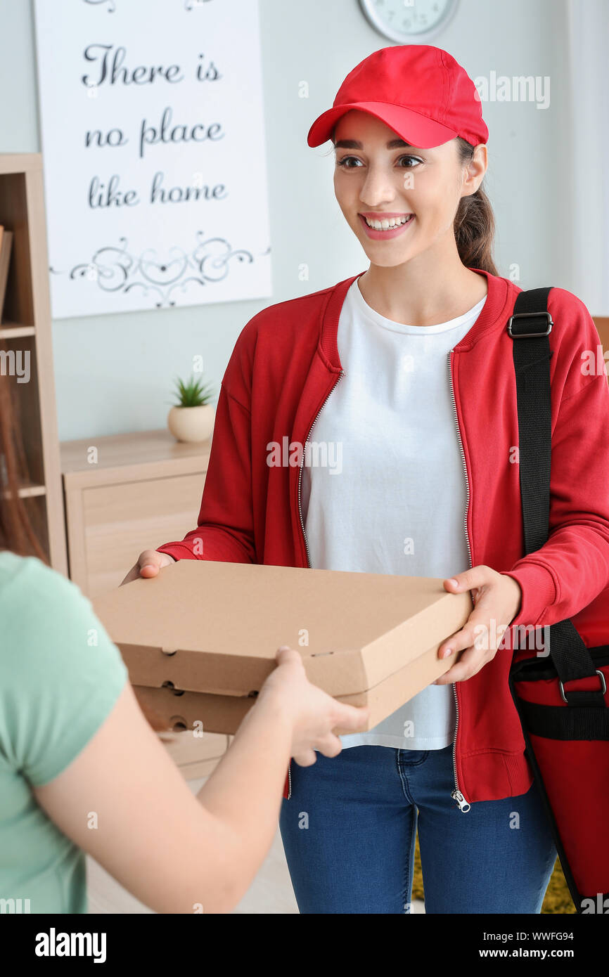 Woman receiving order from courier of food delivery company Stock Photo ...