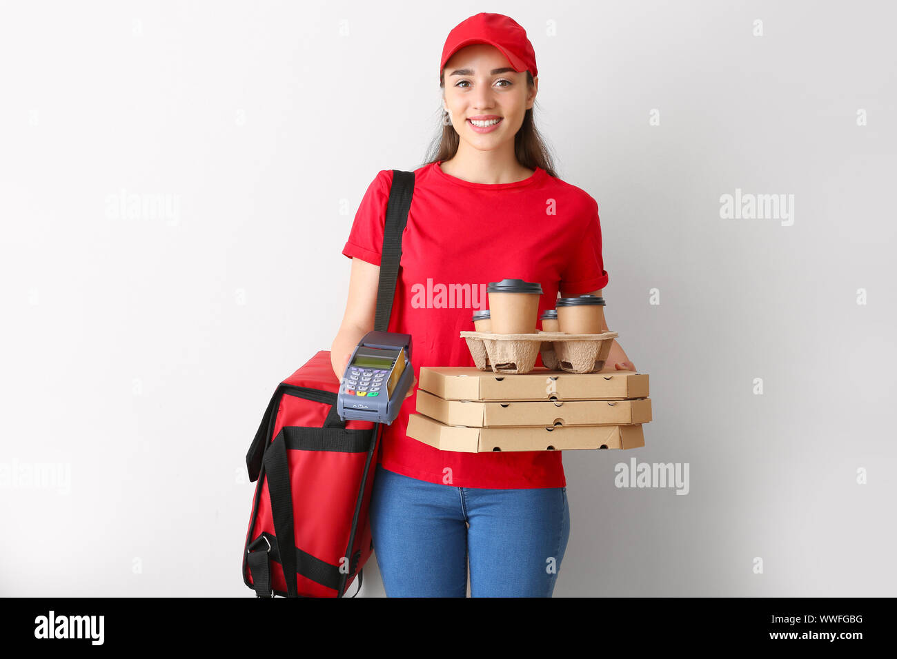 Female worker of food delivery service with payment terminal on white ...