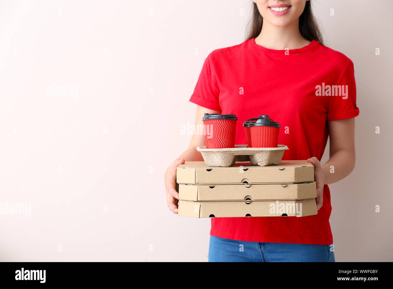 Female worker of food delivery service on white background Stock Photo ...
