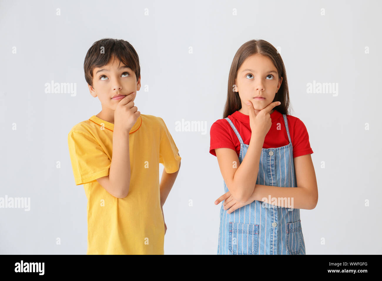 Portrait of thoughtful children on light background Stock Photo - Alamy