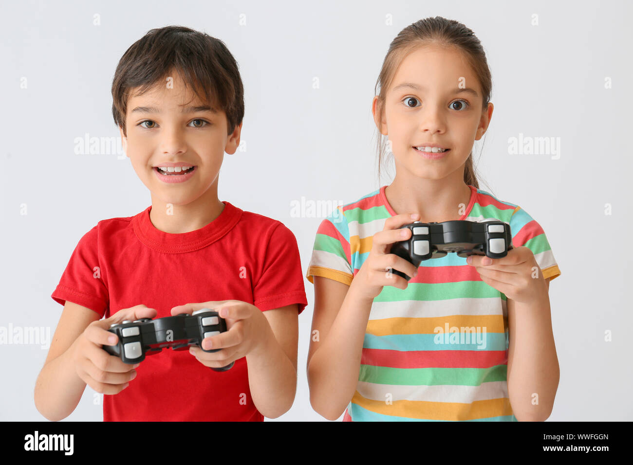 Cute children playing video games on light background Stock Photo - Alamy