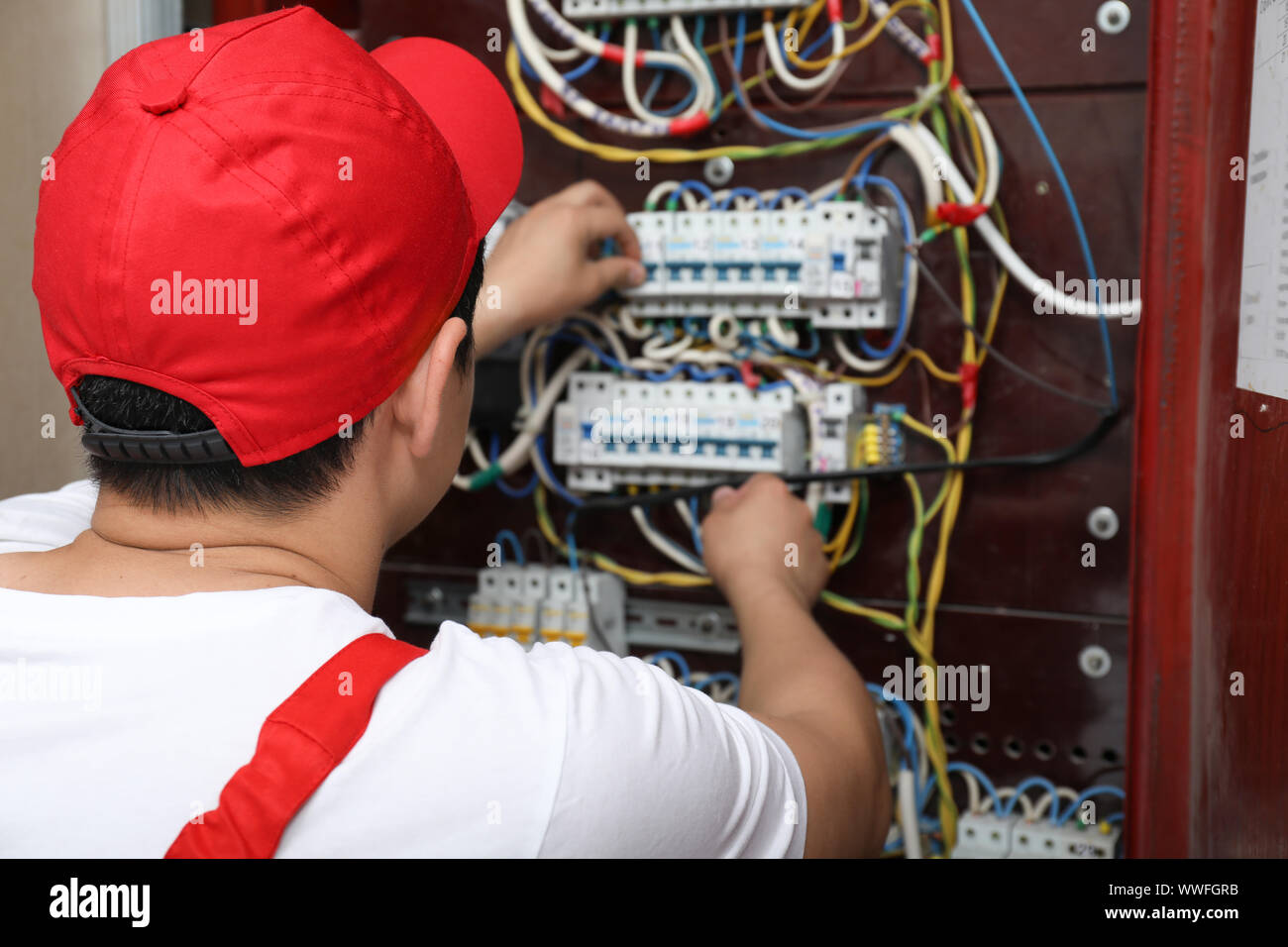 Electrician connecting wires in electric cabinet Stock Photo - Alamy