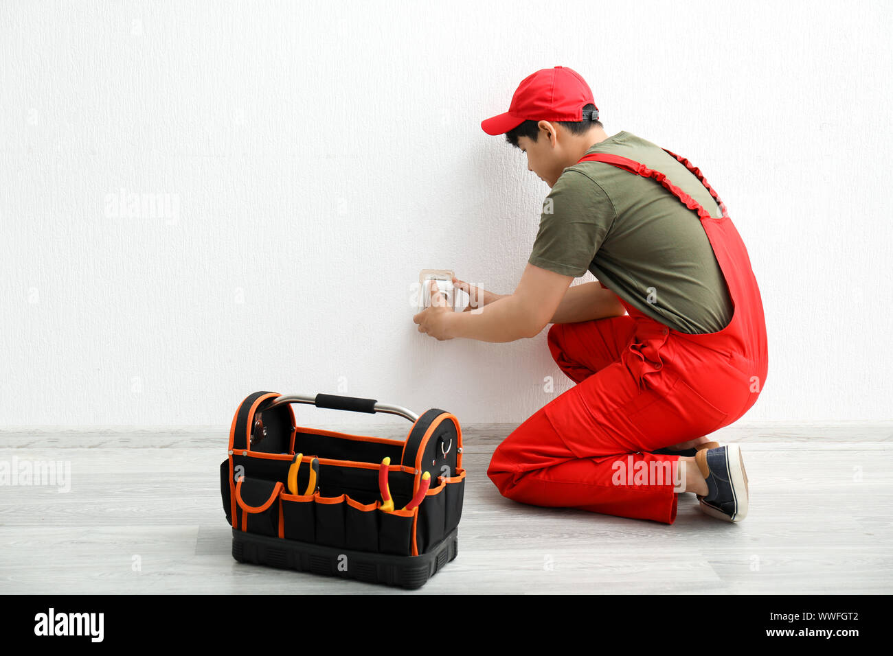 Electrician repairing socket in room Stock Photo - Alamy