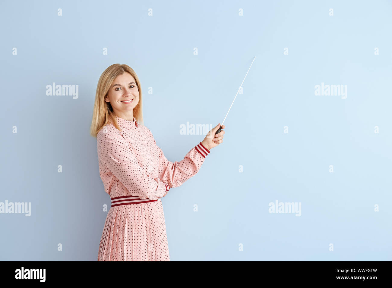 Beautiful female teacher with pointer on color background Stock Photo ...