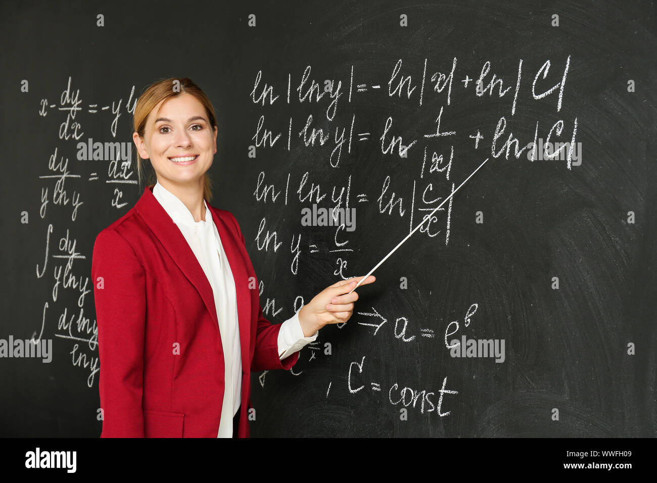 Beautiful math teacher near blackboard in classroom Stock Photo - Alamy