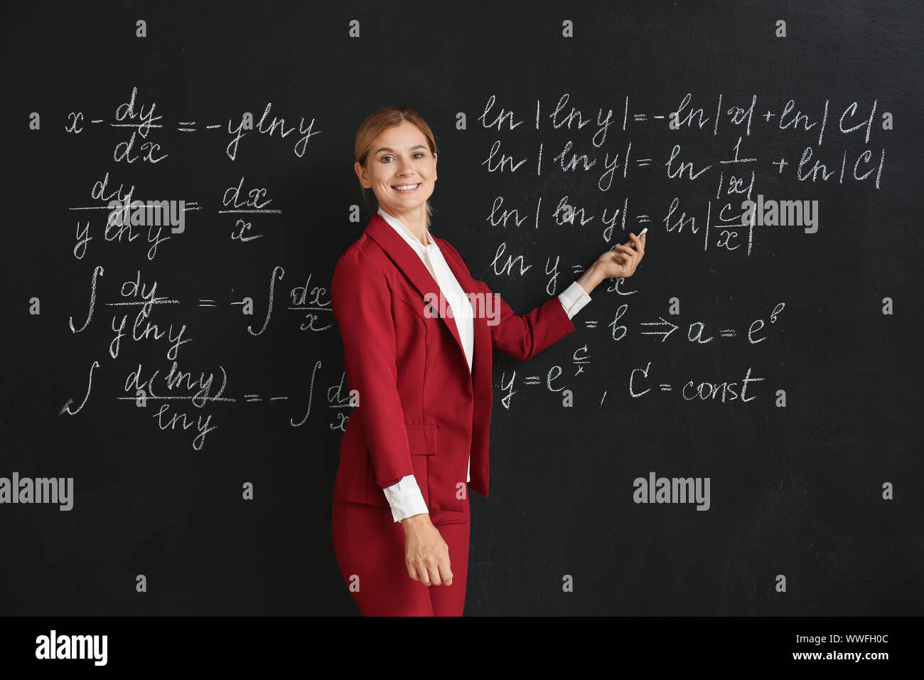 Beautiful math teacher near blackboard in classroom Stock Photo - Alamy