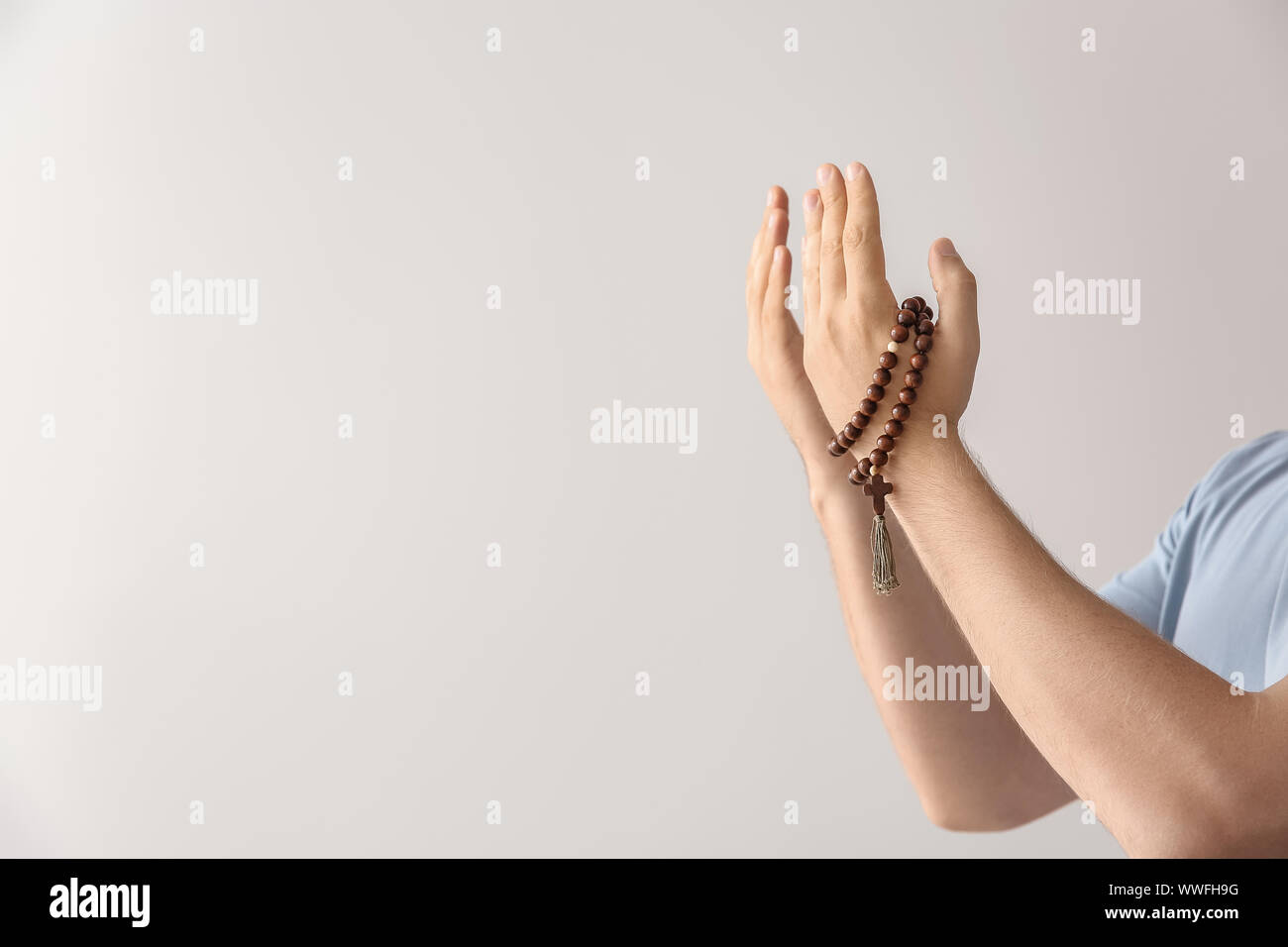 Religious man praying on light background Stock Photo - Alamy