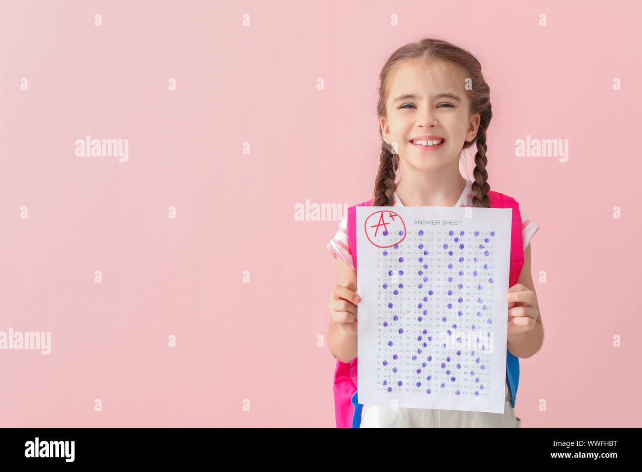 Happy girl with answer sheet for school test on color background Stock ...
