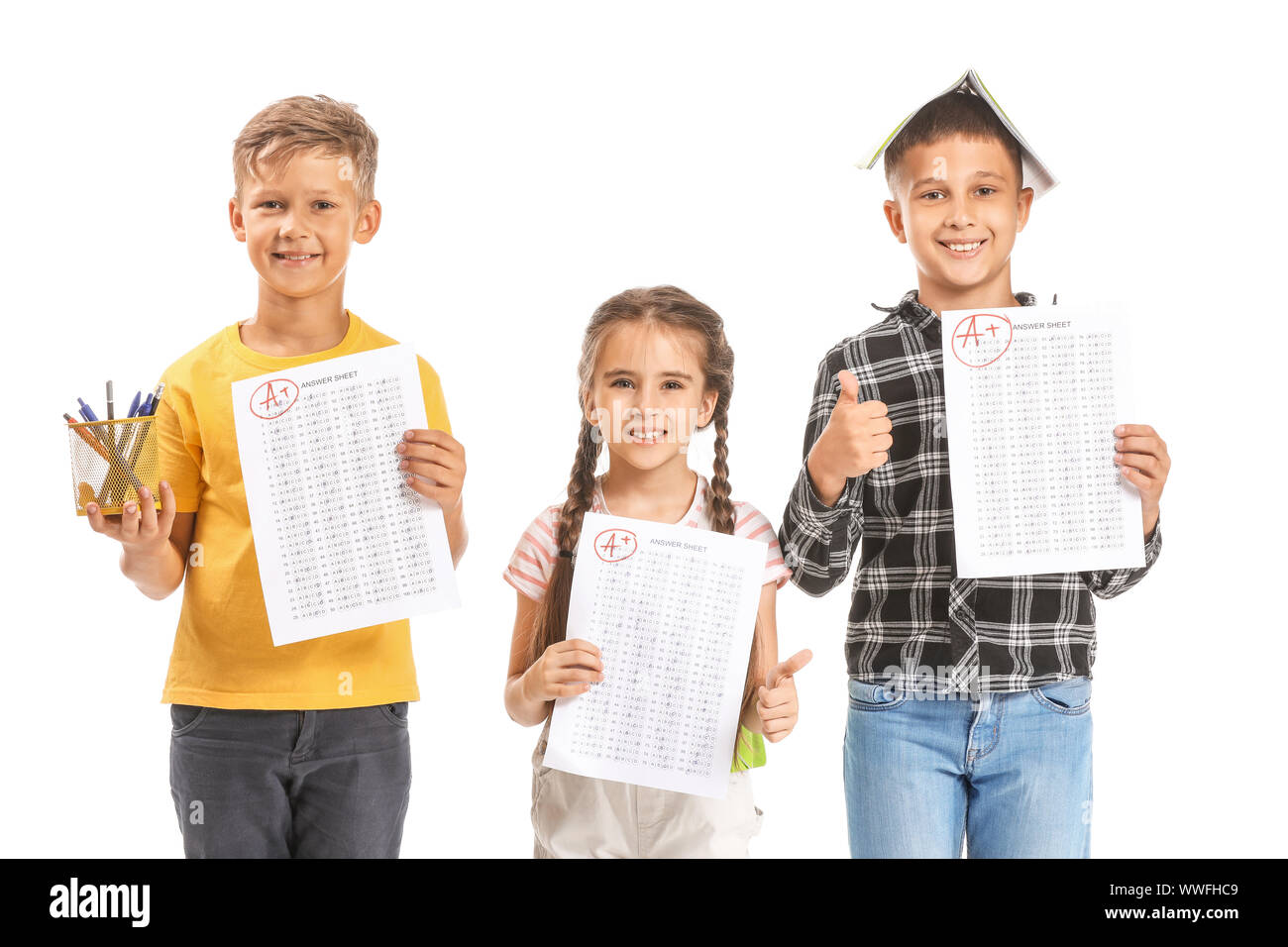 Happy children with answer sheets for school test on white background ...