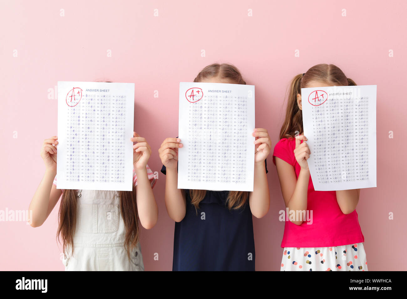 Children with answer sheets for school test on color background Stock ...