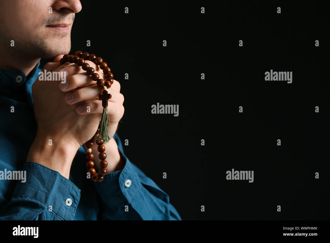 Religious man praying to God on dark background Stock Photo - Alamy