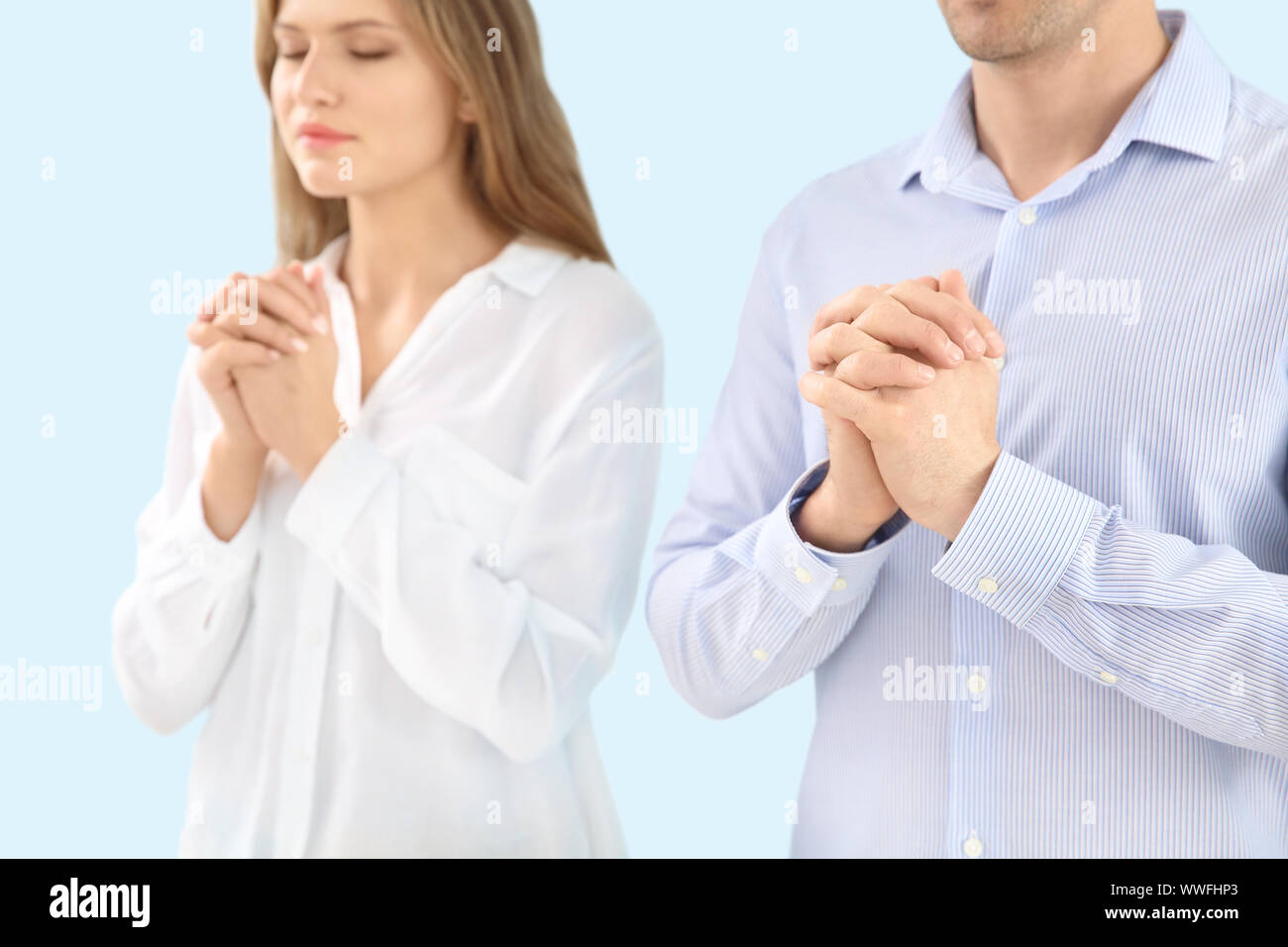 Religious couple praying to God on light color background Stock Photo ...
