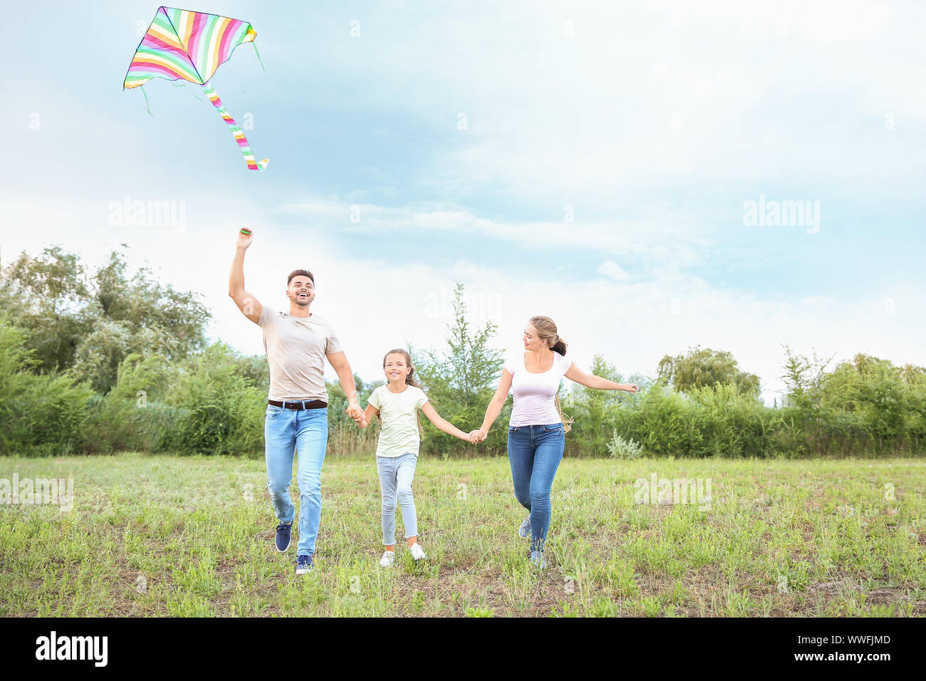 Happy family flying kite outdoors Stock Photo - Alamy