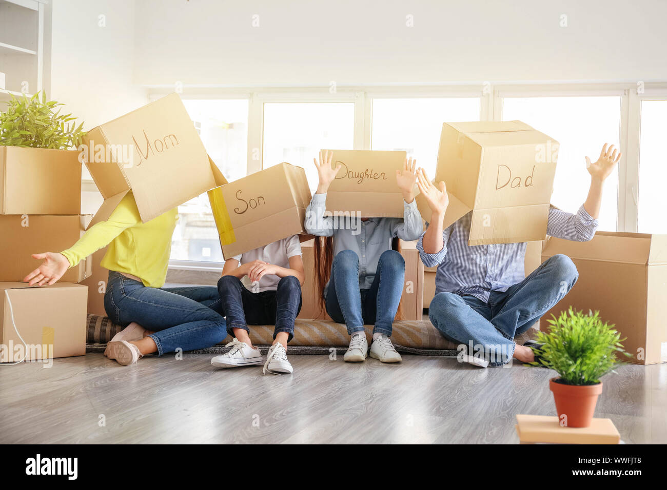 Happy family with moving boxes having fun in their new house Stock ...
