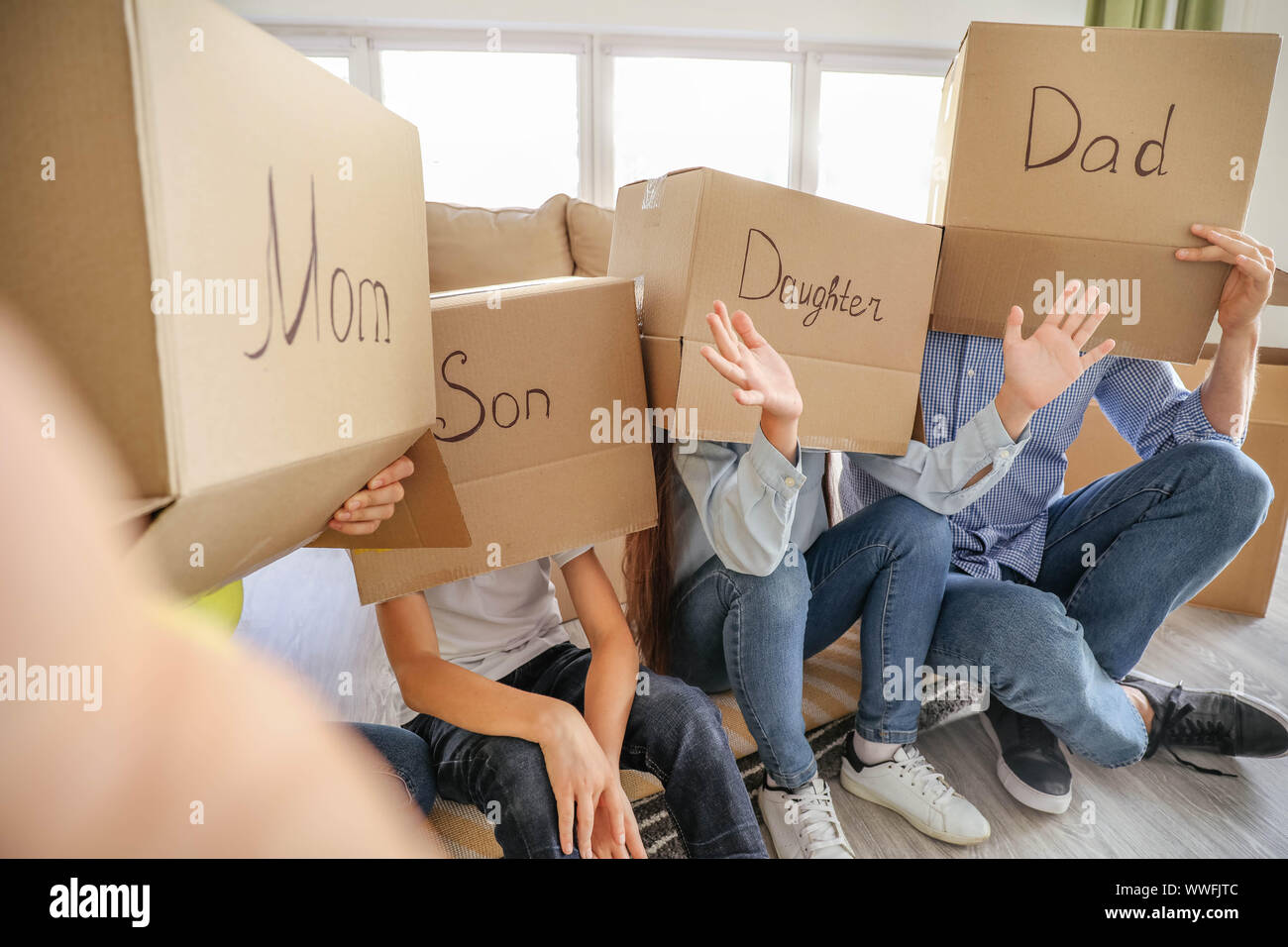 Happy family with moving boxes having fun in their new house Stock ...