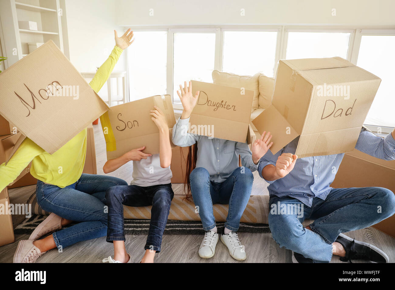 Happy family with moving boxes having fun in their new house Stock ...
