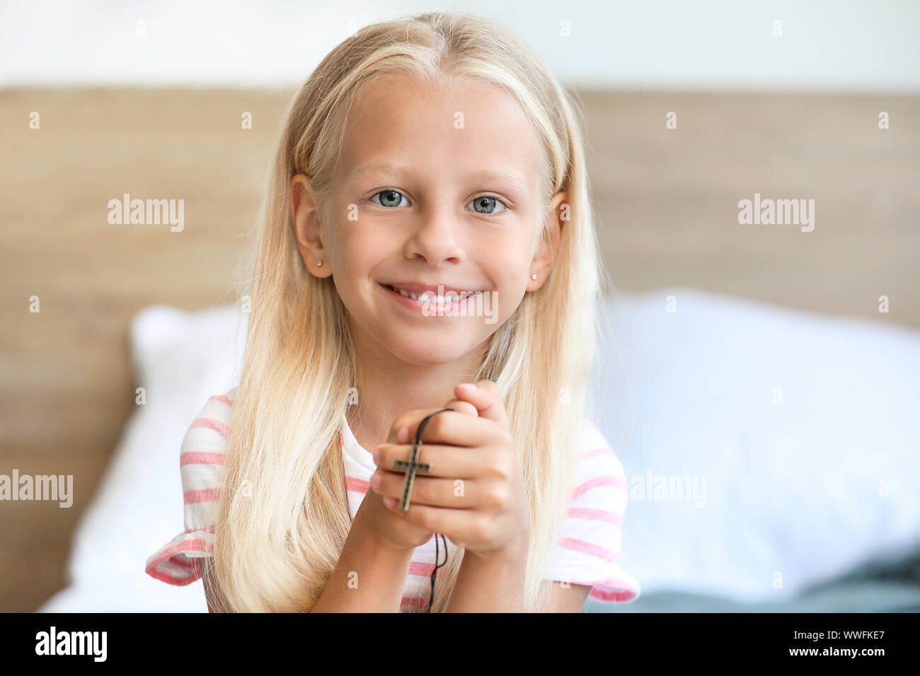 Little girl with cross at home Stock Photo - Alamy