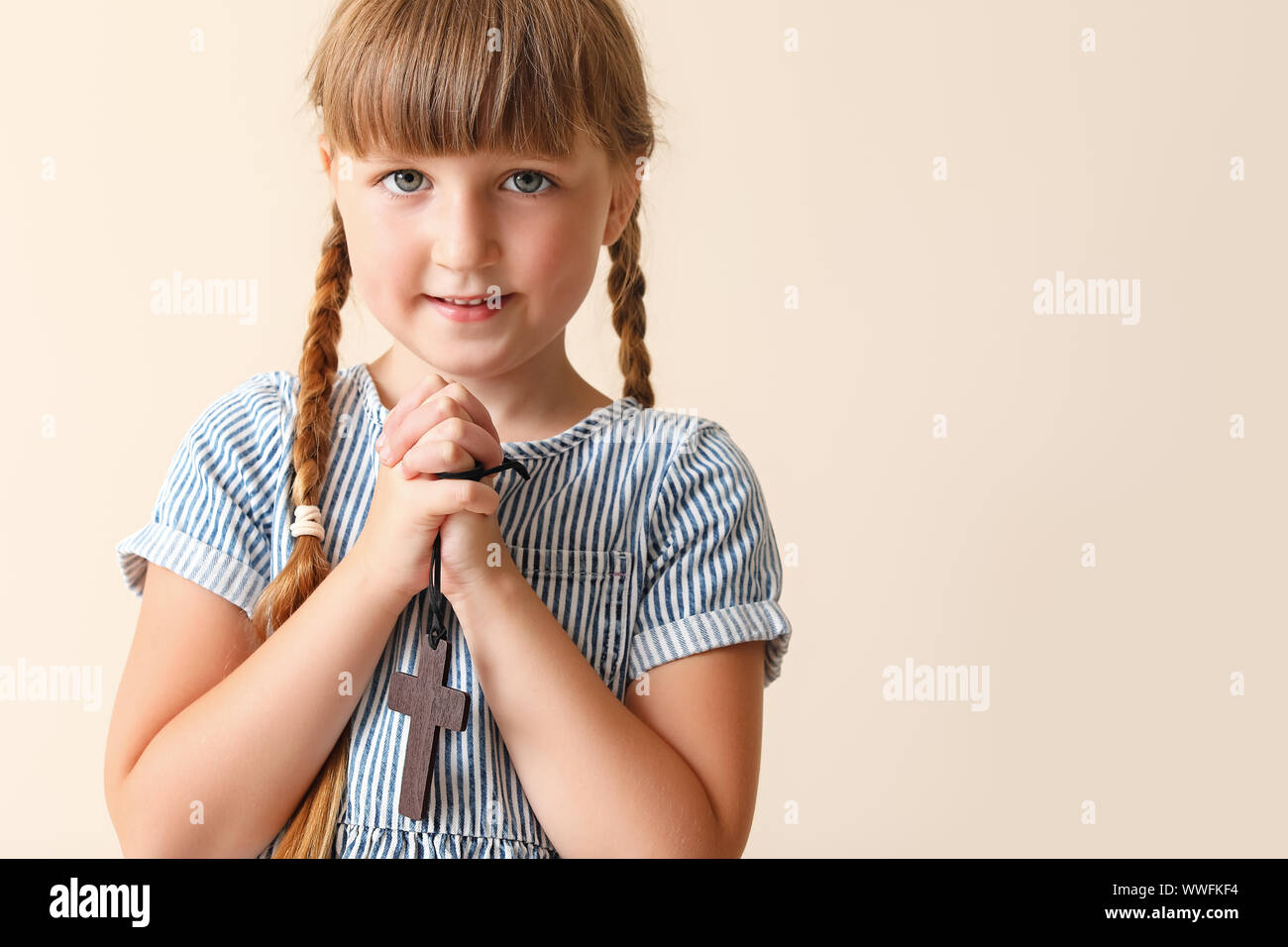 Little girl praying on light background Stock Photo - Alamy