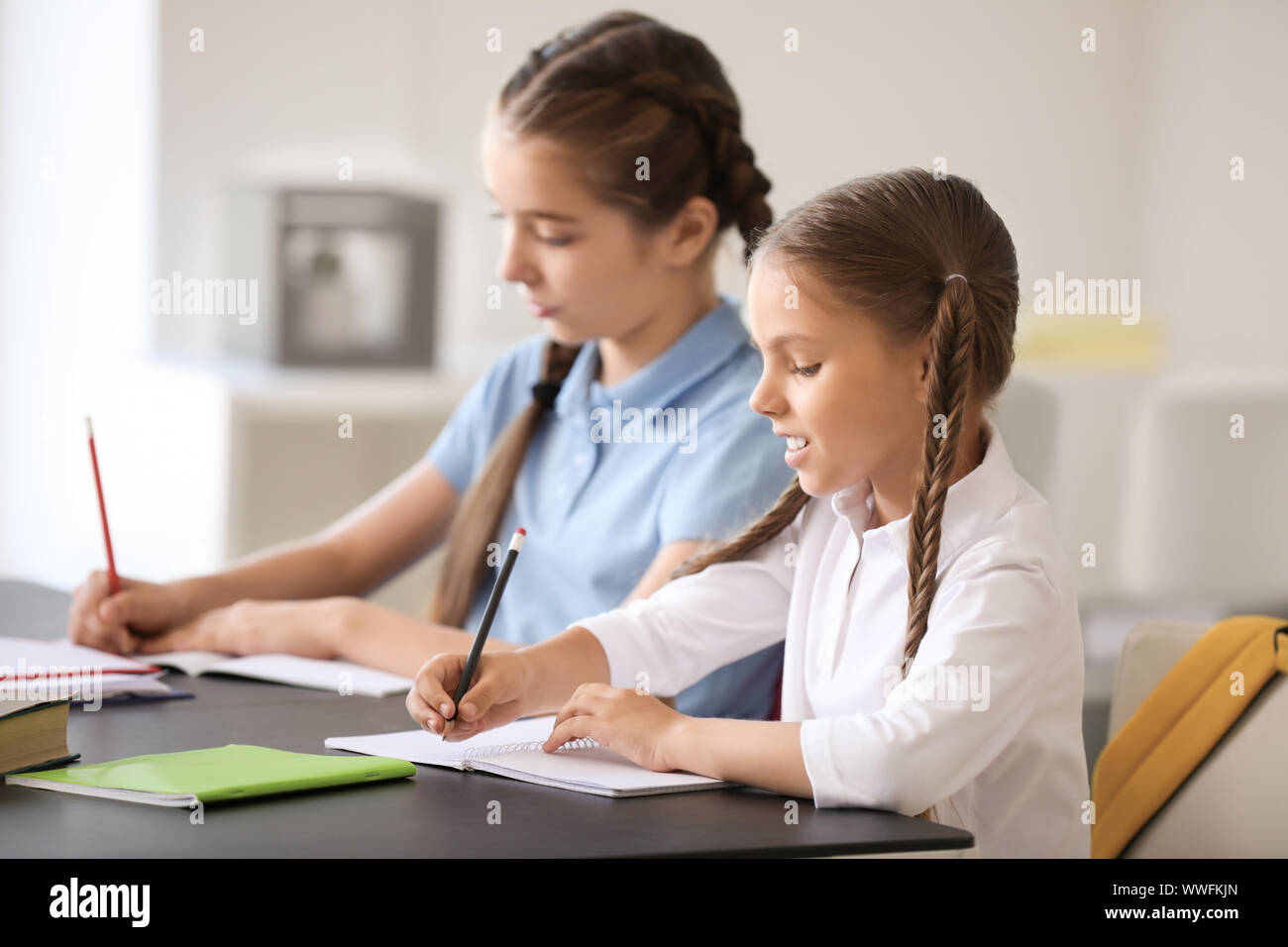 Cute little pupils doing lessons in classroom Stock Photo - Alamy