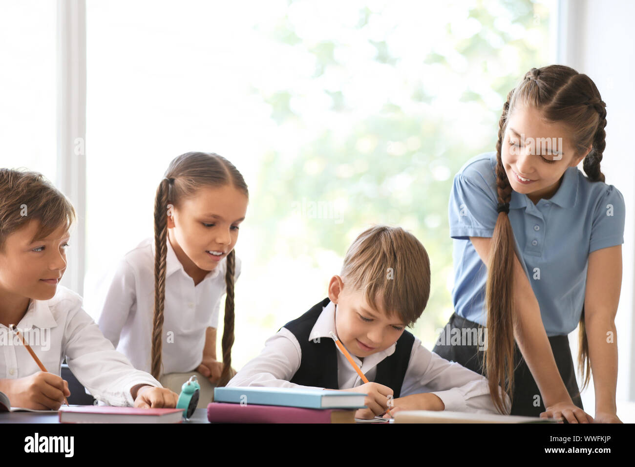 Cute little pupils doing lessons in classroom Stock Photo - Alamy