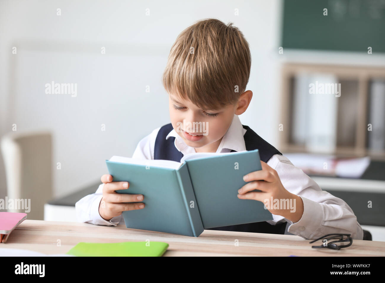 Cute little pupil during lesson in classroom Stock Photo - Alamy