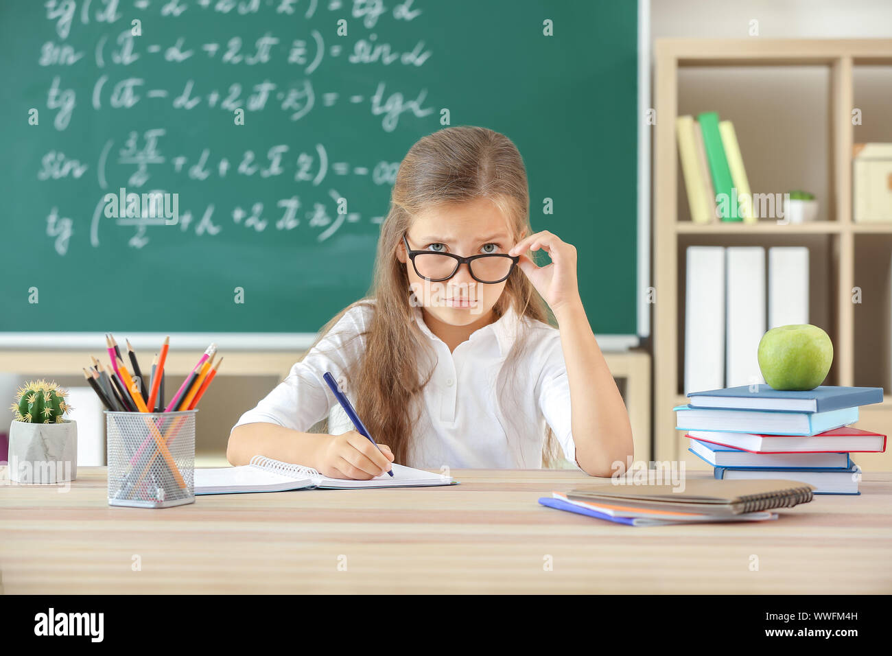 Little girl doing lessons in classroom Stock Photo - Alamy