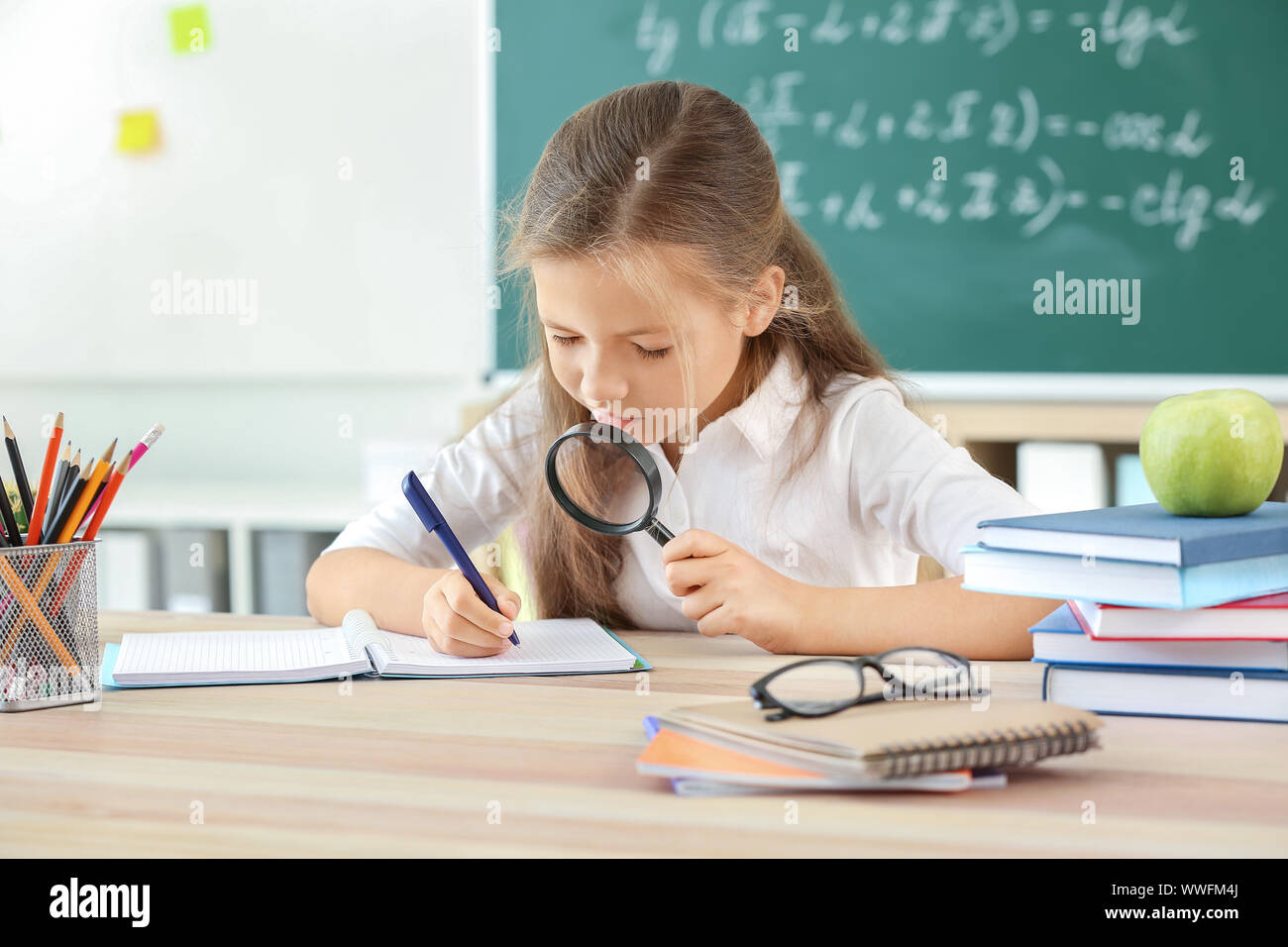 Little girl doing lessons in classroom Stock Photo - Alamy