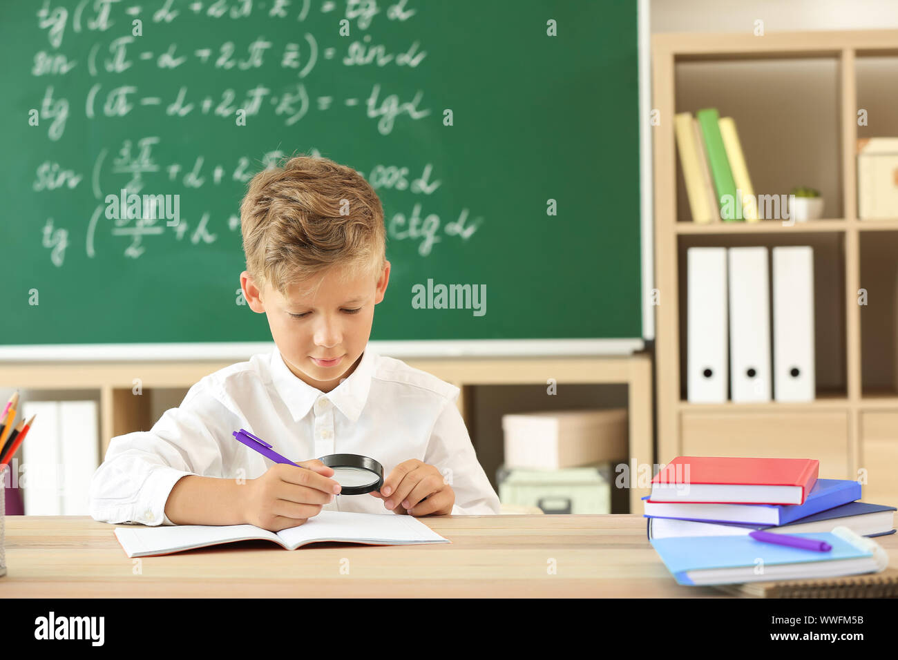 Little boy doing homework in classroom Stock Photo - Alamy